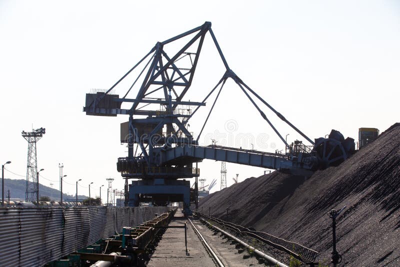 Stacker-reclaimer during Loading and Unloading of Coal. Coal Heaps at a ...