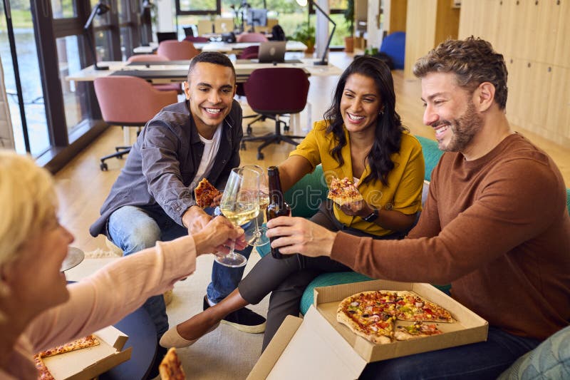 Staff at Informal Meeting in Office with Takeaway Pizza and Drinks ...