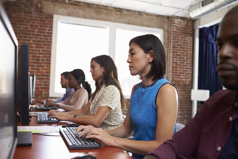 Staff Sitting at Desks Using Computers in Busy Office Stock Image ...