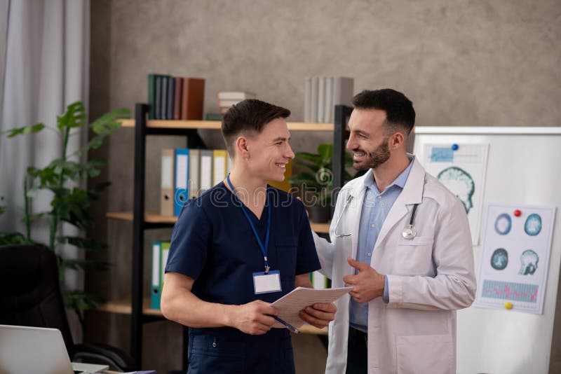 Two Young Male Doctors Talking in the Staffrrom Stock Photo - Image of ...
