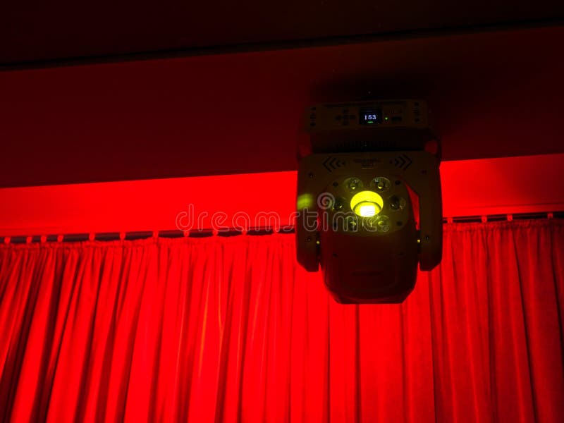 Stage Lighting Fixture with a Red Curtain Backdrop in a Dark Theater ...