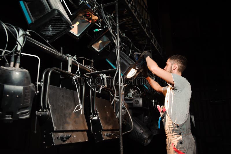 The Stage Worker Sets Up the Lights. the Lighting Engineer Adjusts the ...