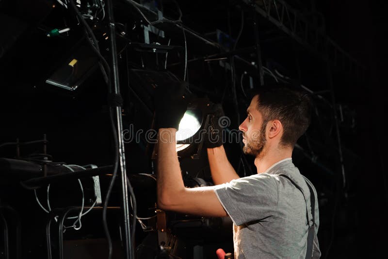 The Stage Worker Sets Up the Lights. the Lighting Engineer Adjusts the ...