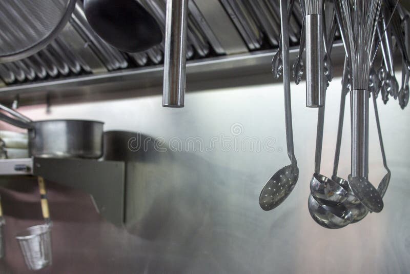 Stainless Steel Kitchen Utensils Hanging from the Dryer in a ...