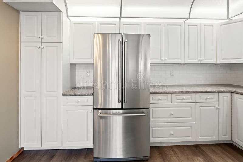 Stainless Steel Refrigerator is in a Kitchen with White Cabinets Stock ...