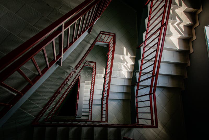 Staircase with Red Railings Descending in a Spiral Stock Image - Image ...