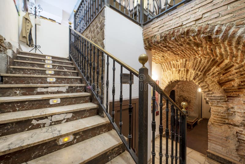 Stairs of a Restaurant with Exposed Brick Base and Wrought Iron Railing ...