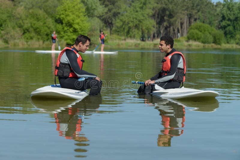 Stand Up Paddle Board Men Talking Stock Image - Image of beach, holding ...