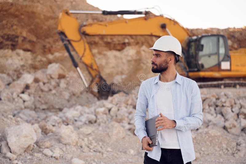 Standing Against Excavator. Man in Uniform is Working in the Quarry at ...