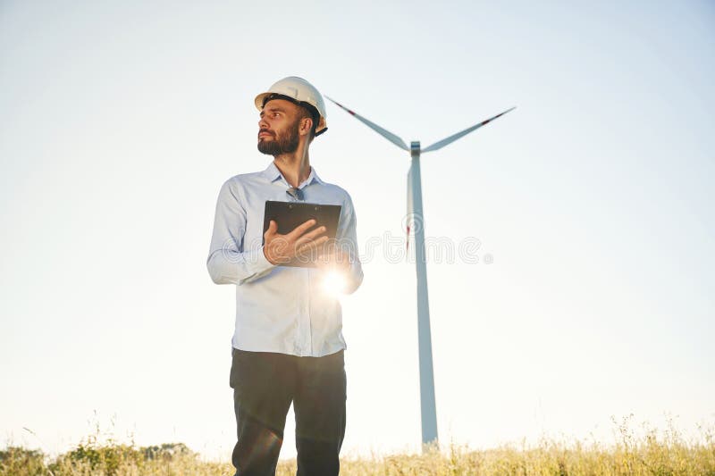 Handsome Service Engineer is Standing on the Field with Windmills Stock ...