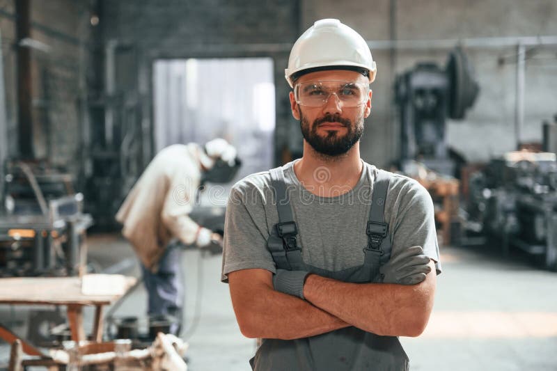 Standing with Arms Crossed. Young Factory Worker in Grey Uniform Stock ...