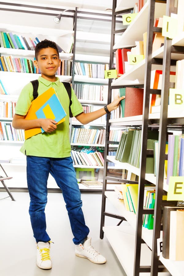 Standing Boy with Books in School Library Stock Photo - Image of ...