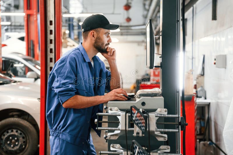 Standing by Computer Terminal. Auto Mechanic Working in Garage Stock ...