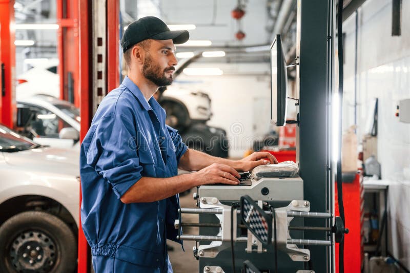Standing by Computer Terminal. Auto Mechanic Working in Garage Stock ...