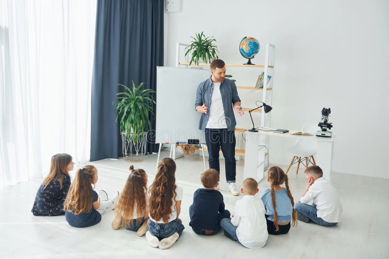 Standing and Explaining Lesson by Using Whiteboard. Group of Children ...