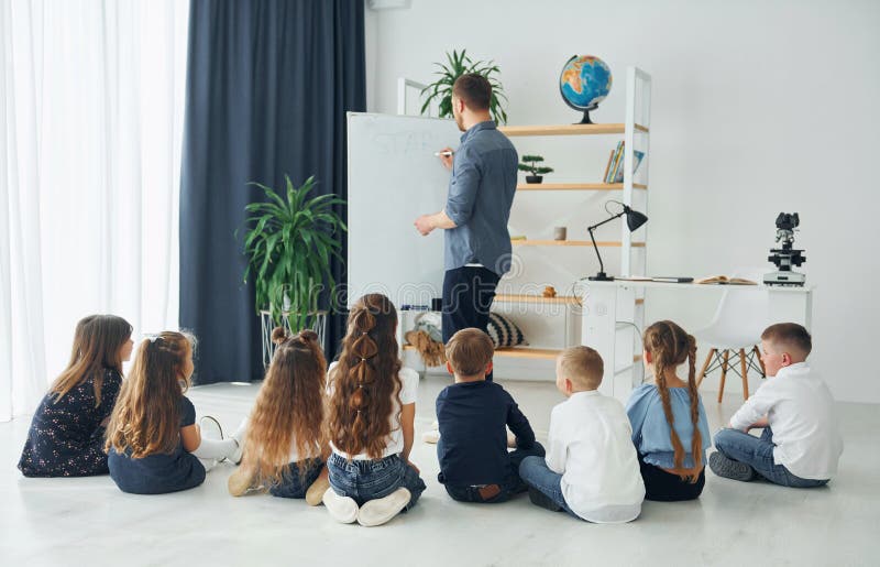 Standing and Explaining Lesson by Using Whiteboard. Group of Children ...