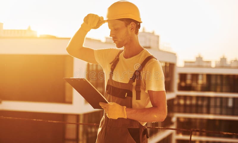 Standing High Up. Young Man Working in Uniform at Construction at ...