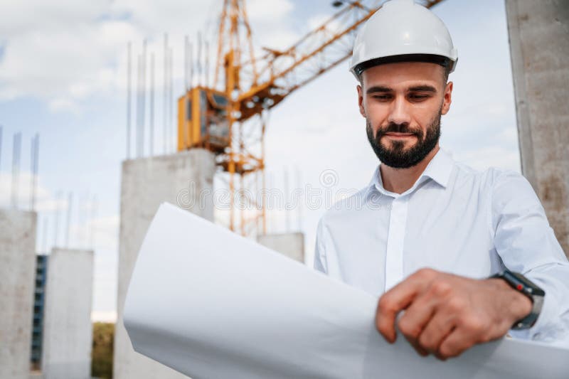 Standing and Holding Plan in Hands. Man in Uniform is Working on the ...