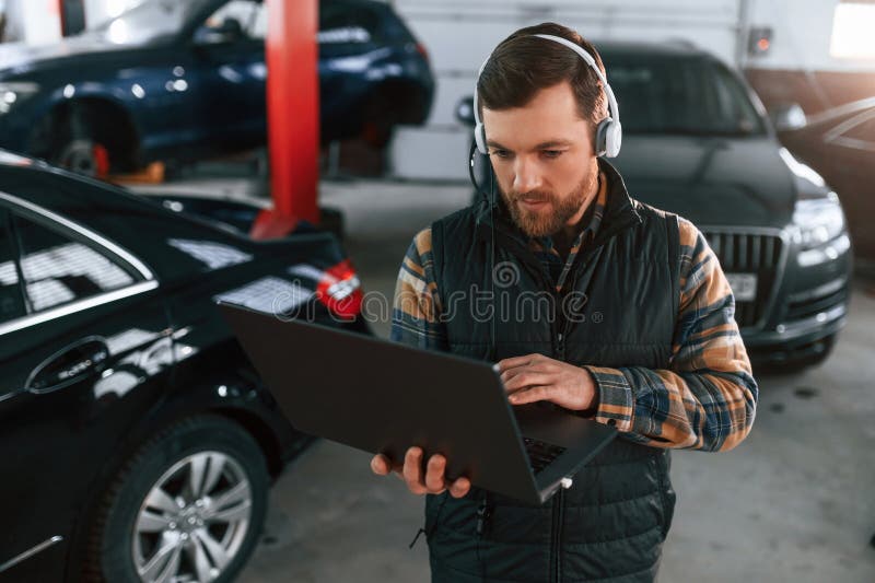 Standing with Laptop in Hands and in Headphones. Man in Uniform is ...