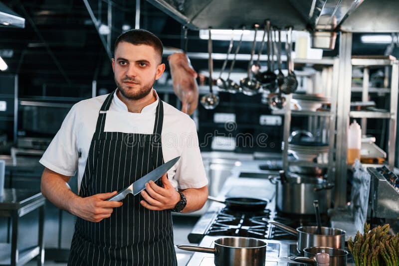 Standing and Looking at the Camera. Chef is on the Kitchen Preparing ...