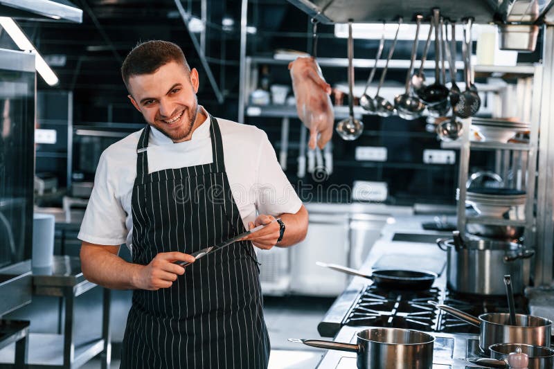Standing and Looking at the Camera. Chef is on the Kitchen Preparing ...