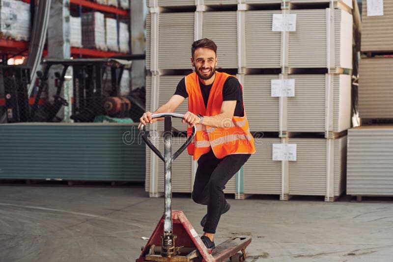 Standing with Platform Trolley. Storage Worker is in the Warehouse with ...