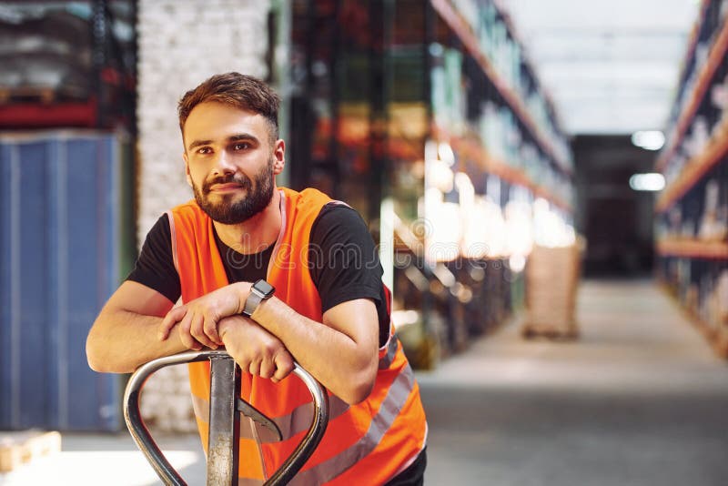Standing with Platform Trolley. Storage Worker is in the Warehouse with ...