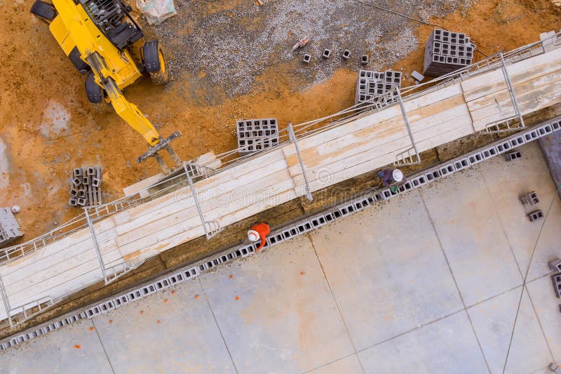 Standing on Scaffold, Bricklayer Constructs a Working Concrete Wall ...