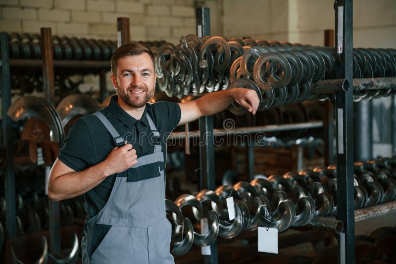 Standing and Smiling. Man in Uniform is in Workstation Developing ...