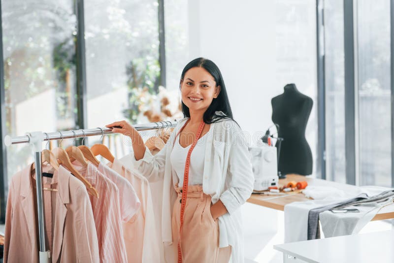 Standing and Smiling. Seamstress is in Her Office that is with ...