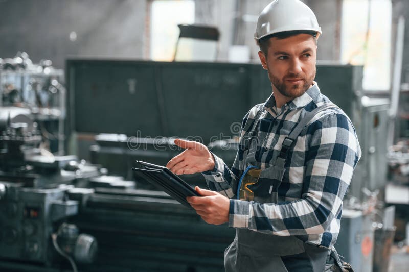 Standing and Using Graphic Tablet. Factory Male Worker in Uniform is ...