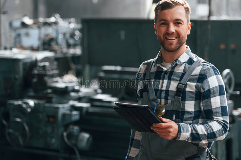 Standing and Using Graphic Tablet. Factory Male Worker in Uniform is ...
