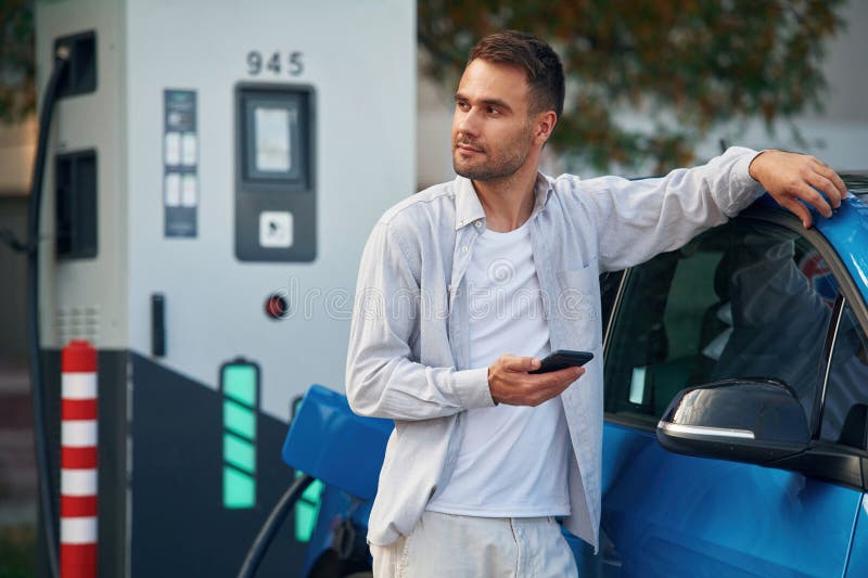 Standing and Waiting for Process Finished. Man with Blue Electric Car ...
