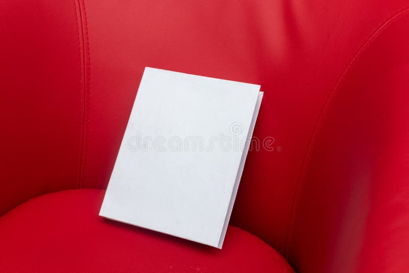 A Standing White Colored Hardcover Book Placed on the Top of a Red Sofa ...