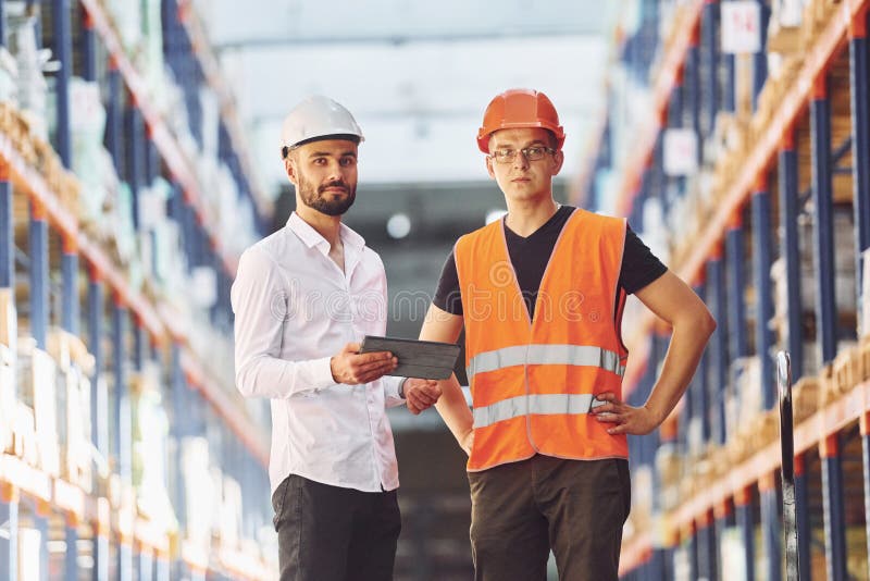 Standing and Working Together. Two Men in Storage is in the Warehouse ...