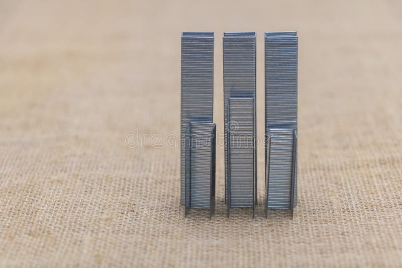 Staples: Three Straight, Short Silver Metal Stems on a Tabletop, Viewed ...