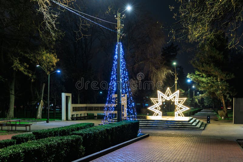 Star-shaped Light Display and Illuminated Trees in Nighttime Park Scene ...