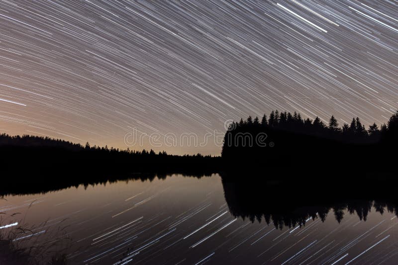 Star Trails in a Starry Night in Front of a Reservoir with Reflections ...
