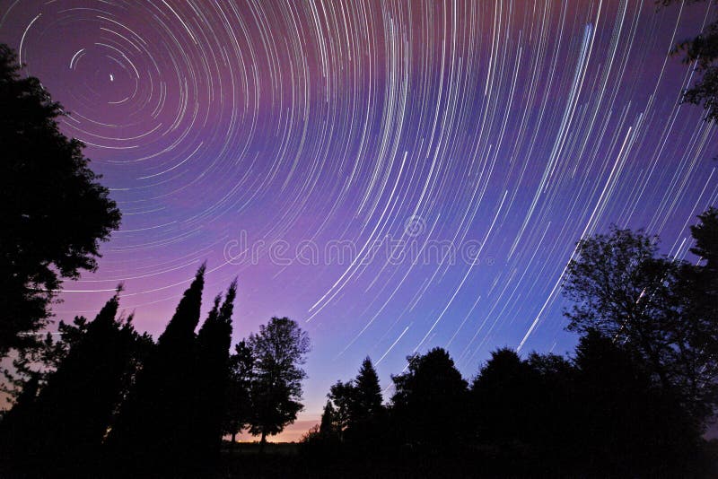 Star Trails at Sunset Behind Row of Trees Stock Photo - Image of glow ...
