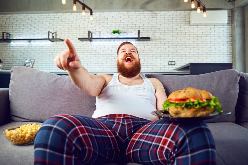 Starker Lustiger Mann Mit Einem Burger, Der Auf Der Couch Sitzt ...