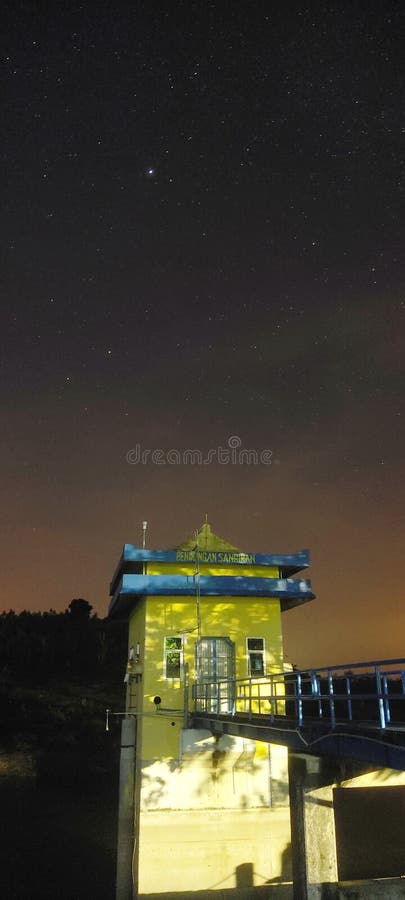 Starry Night in the Black Sky and Setting Sun and Yellow Building Stock ...