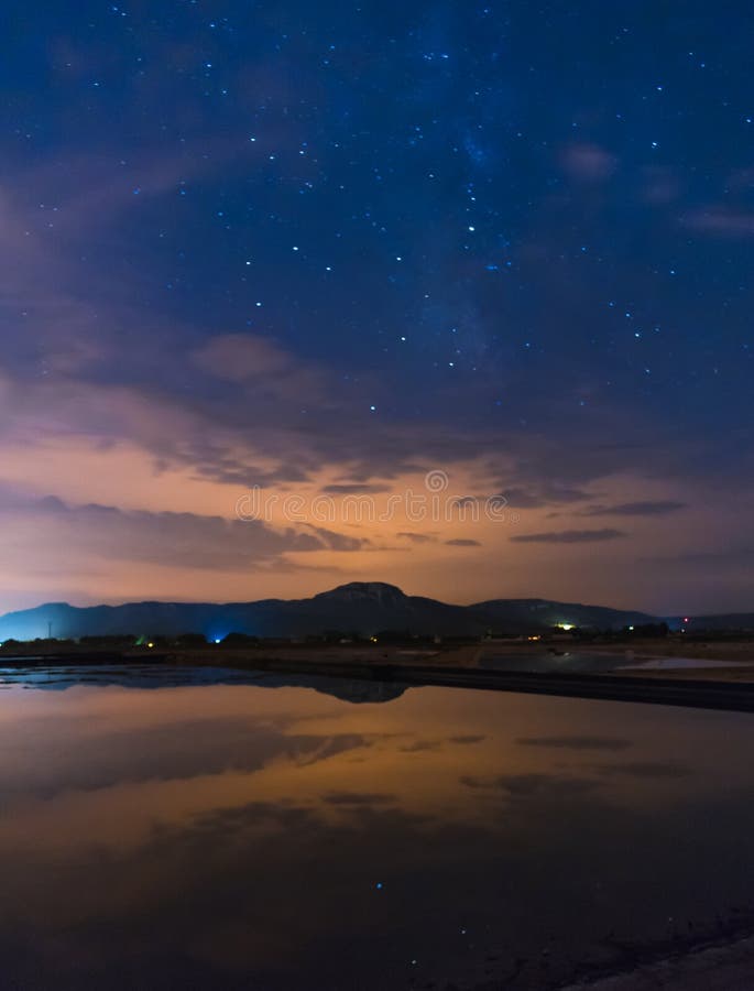 Starry Sky Reflected in the Water with Some Clouds on Top of a Mountain ...