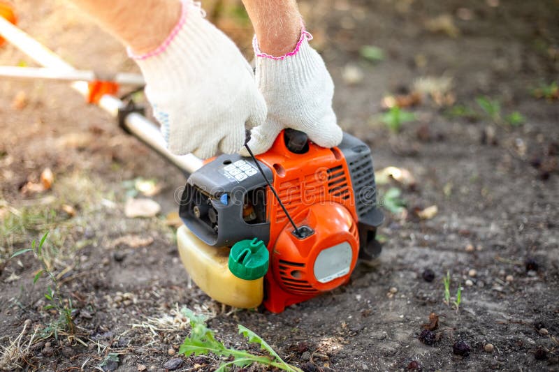 Starting a Gas Mower To Mow Grass. a Man Pulls the Recoil Starter To ...