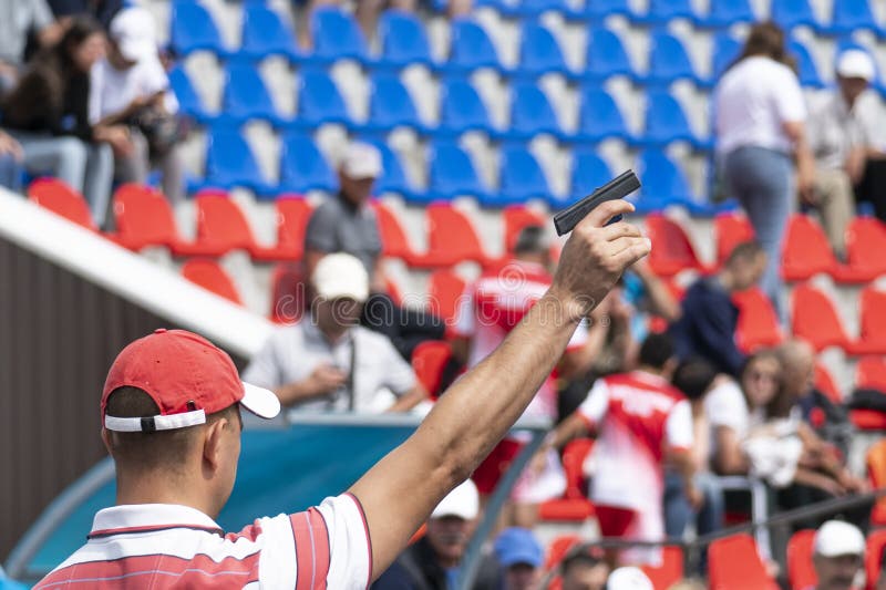 Starting Pistol in a Man& X27;s Hand at the Stadium. Start of Running ...