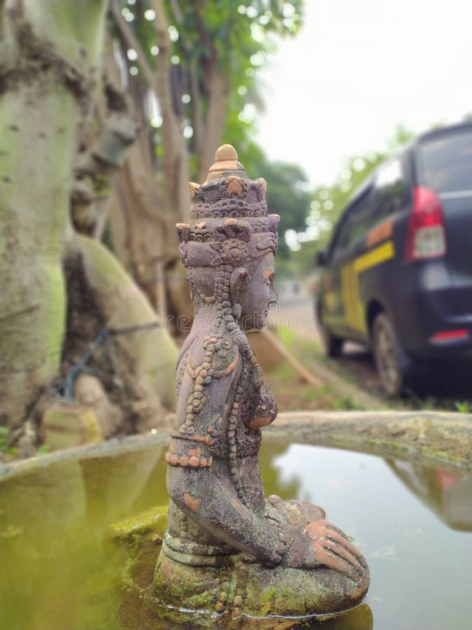Statue above the fish pond stock photo. Image of water - 334431406