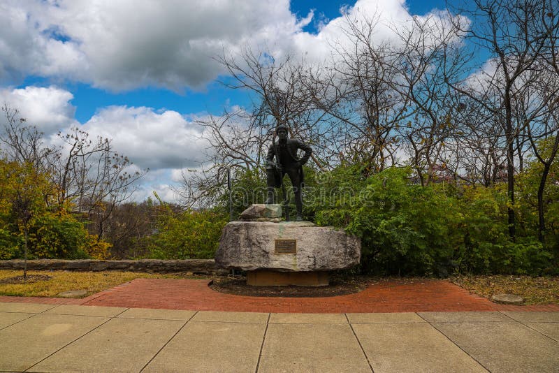 A Statue of an Explorer on the Sidewalk Surrounded by Lush Green and ...