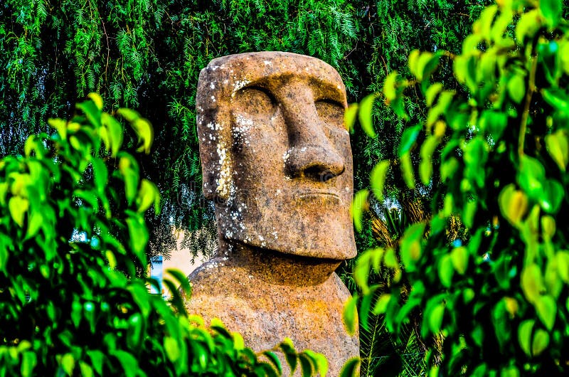 A Statue of a Man with a Beard and a Stone Face is Surrounded by Green ...
