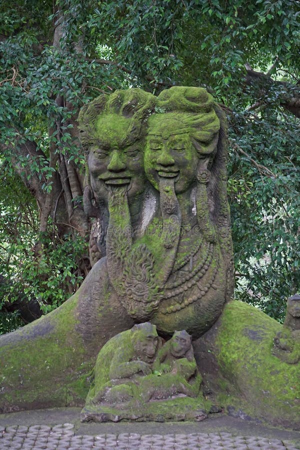 Mossy Statue in Bali Indonesia with Jungle and Palm Trees in the Back ...