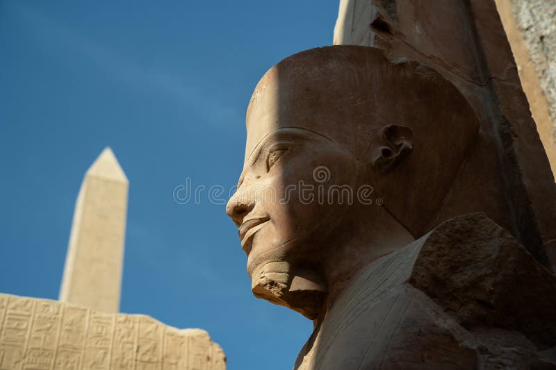 Statue of a Pharaoh with an Abelisk in the Background in Luxor Stock ...