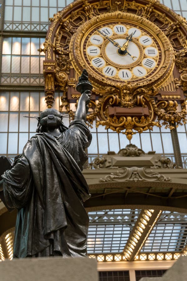 Statue Points Towards Large Golden Clock Stock Photo - Image of face ...